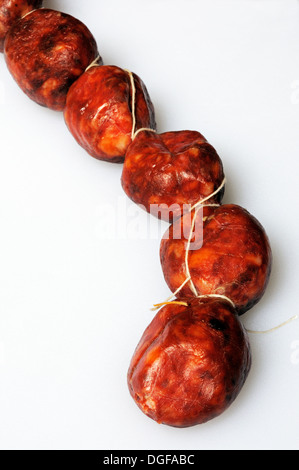 String of Spanish mini chorizo sausages against a white background ...