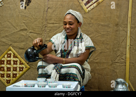 Ethiopian traditional Coffee ceremony women in traditional dress preparing bunna coffee in Addis ...