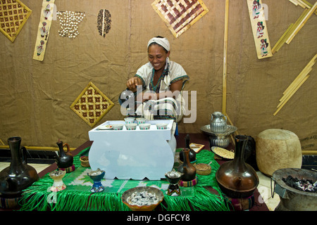 Ethiopian traditional Coffee ceremony women in traditional dress preparing bunna coffee in Addis ...