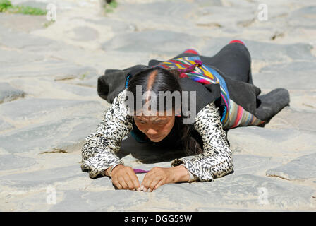 Tibetan pilgrim lying in prostration, Tashilhunpo Monastery, Shigatse ...