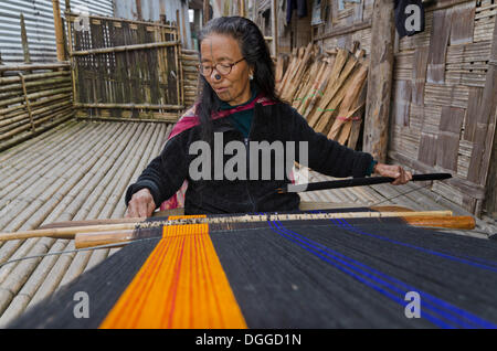 Apatani woman weaving material at a traditional hand loom, Hani ...