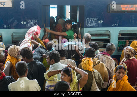 Crowds of people pushing inside a train, on a platform of the railway ...