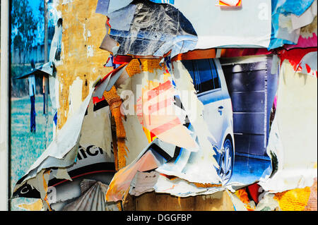 old billboard with ripped advertising posters hanging off in Luton ...