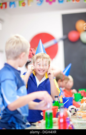 smiling boy in birthday party hat over confetti Stock Photo - Alamy