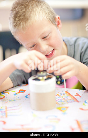 Boy making craft object Stock Photo - Alamy