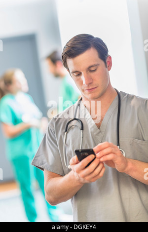 Nurse texting on cell phone near patient Stock Photo - Alamy