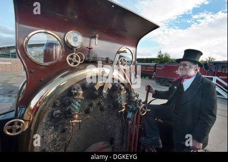 An engine driver in period victorian costume inspects his steam ...