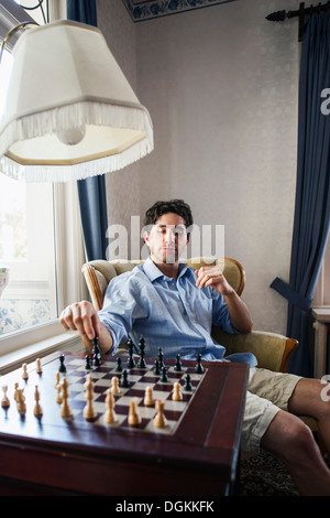 Young caucasian man playing chess sitting on the table celebrating ...