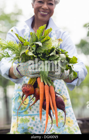 Portrait of a woman with carrots - focus on woman Stock Photo - Alamy