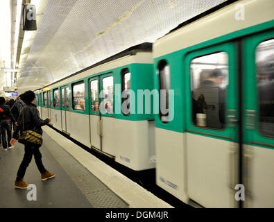 People entering a Paris Metro station through the turnstile, Paris ...