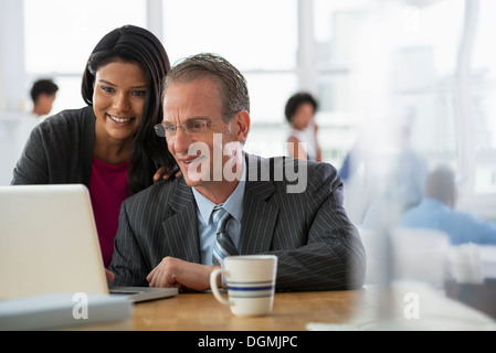 Middle age man and woman business partners writing on notebook scanning ...