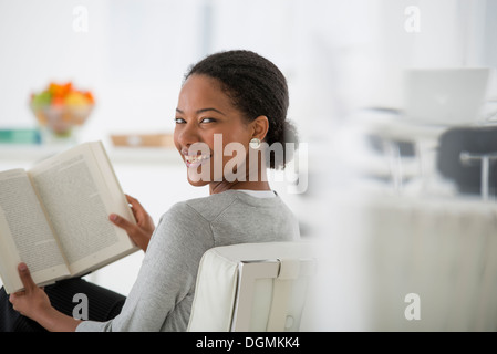 Woman reading book, over the shoulder view Stock Photo - Alamy