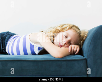 Girl (4-5) sleeping on bench indoors Stock Photo - Alamy