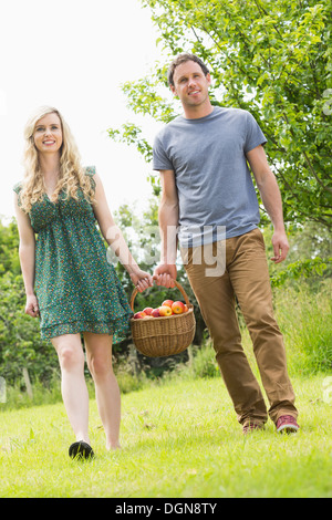 Smiling woman carrying a basket of sweet potatoes on her head in ...
