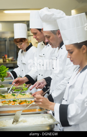 Four serious concentrated male and female students of different ...