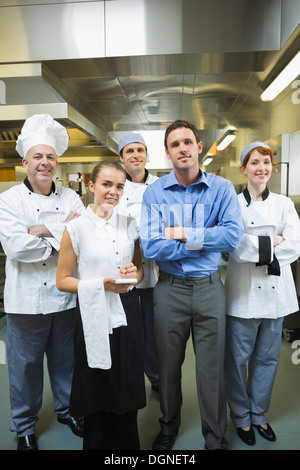 Team of restaurant staff posing together in modern professional kitchen ...