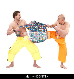 Two men pulling on a colorful shirt Stock Photo - Alamy