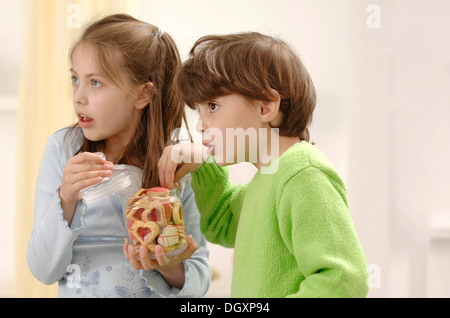 Girl and boy nibbling on Christmas cookies Stock Photo - Alamy