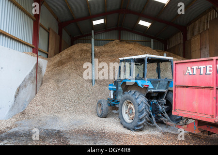biomass storage shed with tractor and trailer Stock Photo - Alamy