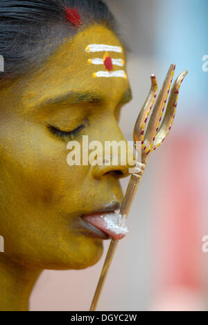 Shiva devotee with pierced tongue and the symbol of Shiva, the trident ...