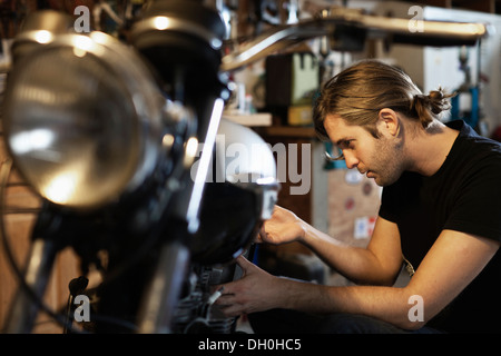 A mechanic working on his motorcycle Stock Photo - Alamy