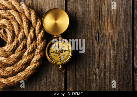 Antique compass and rope over wooden background Stock Photo - Alamy
