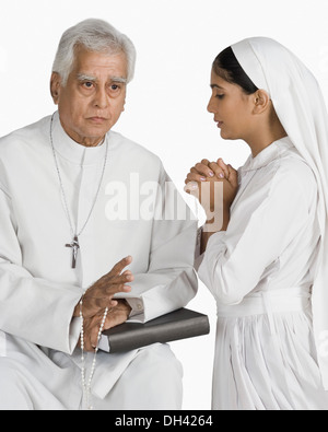 Catholic confession – a woman confessing to a Catholic priest – during ...