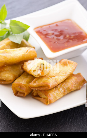 Fried spring rolls on black slate plate on grey stone slate background ...