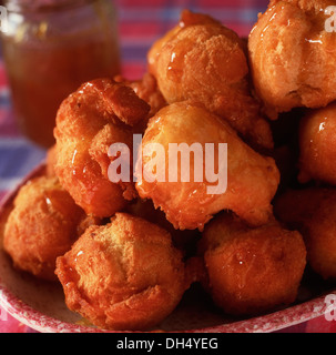Golden fried dough balls served on parchment paper inside a rustic ...