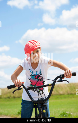 One caucasian children rides bike road in autumn park. Little girl ...
