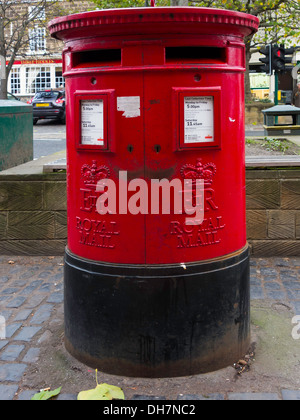 A traditional red double fronted Royal Mail post box with boxes ...