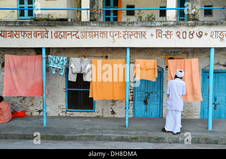 Traditional Indian street laundry man (dhobi) ironing washing on a cart ...
