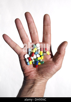 Man holding variety of medicine pills, capsules and tablets in his ...