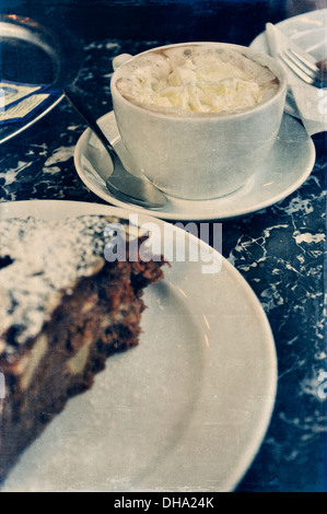 Coffee and cake with cream on the table. Female drinking coffee and ...