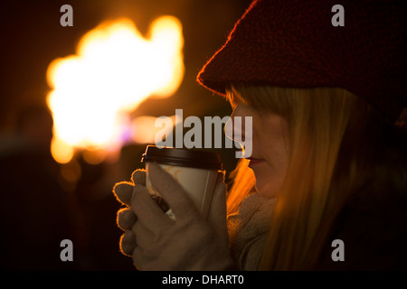 Woman drinking coffee at bonfire night celebration Stock Photo - Alamy