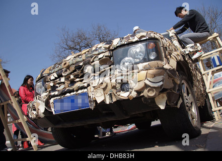 Landrover decorated with pottery and porcelain Workers decorate a Land ...