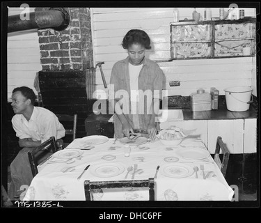 Mrs. James Robert Howard sets the table for supper in their home in ...