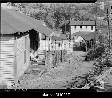 The image depicts typical houses and a street in a mining community ...