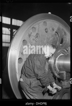 A machinist at Baldwin Locomotive Works in 1937 works on machining a ...