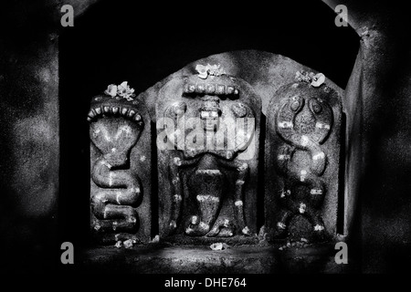 Hindu shrine stones at a temple depicting Indian vishnu deity in rural ...