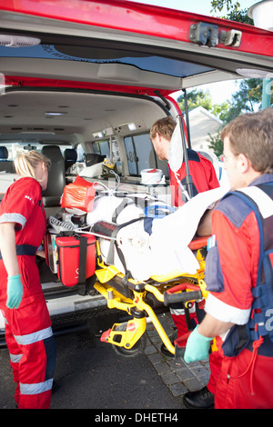 Paramedics lifting patient into ambulance Stock Photo - Alamy