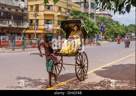 Human pulling rickshaw with passenger in Calcutta, India Stock Photo ...