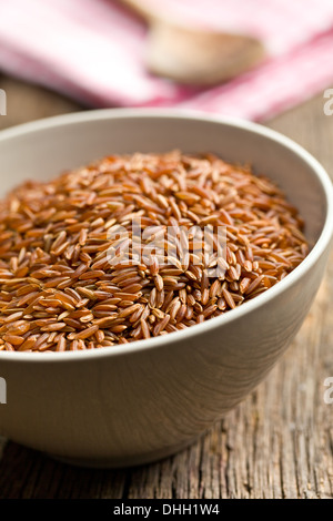bowl of red rice on wooden cutting board Stock Photo - Alamy