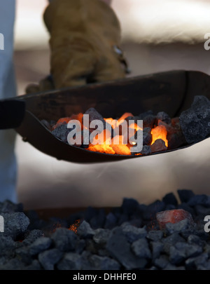 Blacksmith working near burning hearth Stock Photo - Alamy