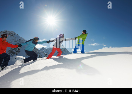 Friends pulling each other uphill in snow, Kuhtai, Austria Stock Photo ...