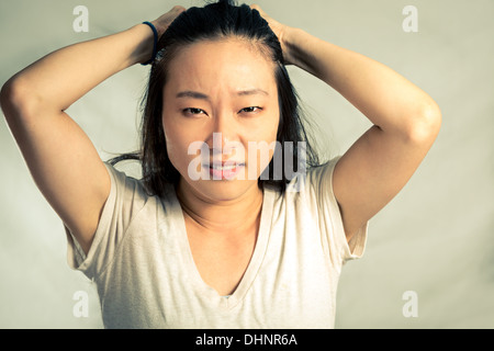 Young girl looking down and pulling hair behind her ear Stock Photo - Alamy