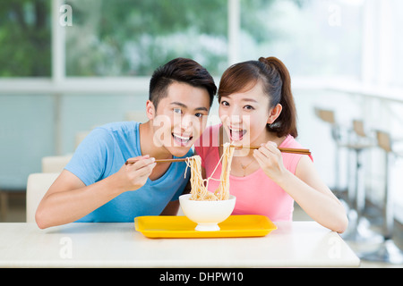 Portrait of Smiling couple having noodles Stock Photo - Alamy
