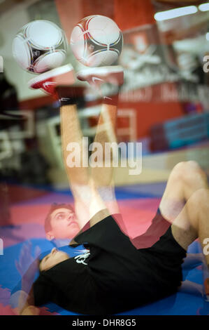 Soccer freestyler Marcel Gurk lies on his back and balances a ball on ...
