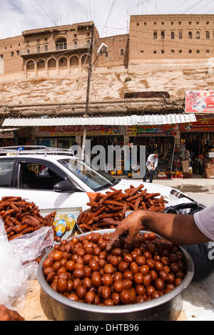 Sweets sold in a street market with citadel in background. Erbil, Iraq ...
