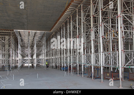 A builder walks between 8 metre high aluminium formwork support ...
